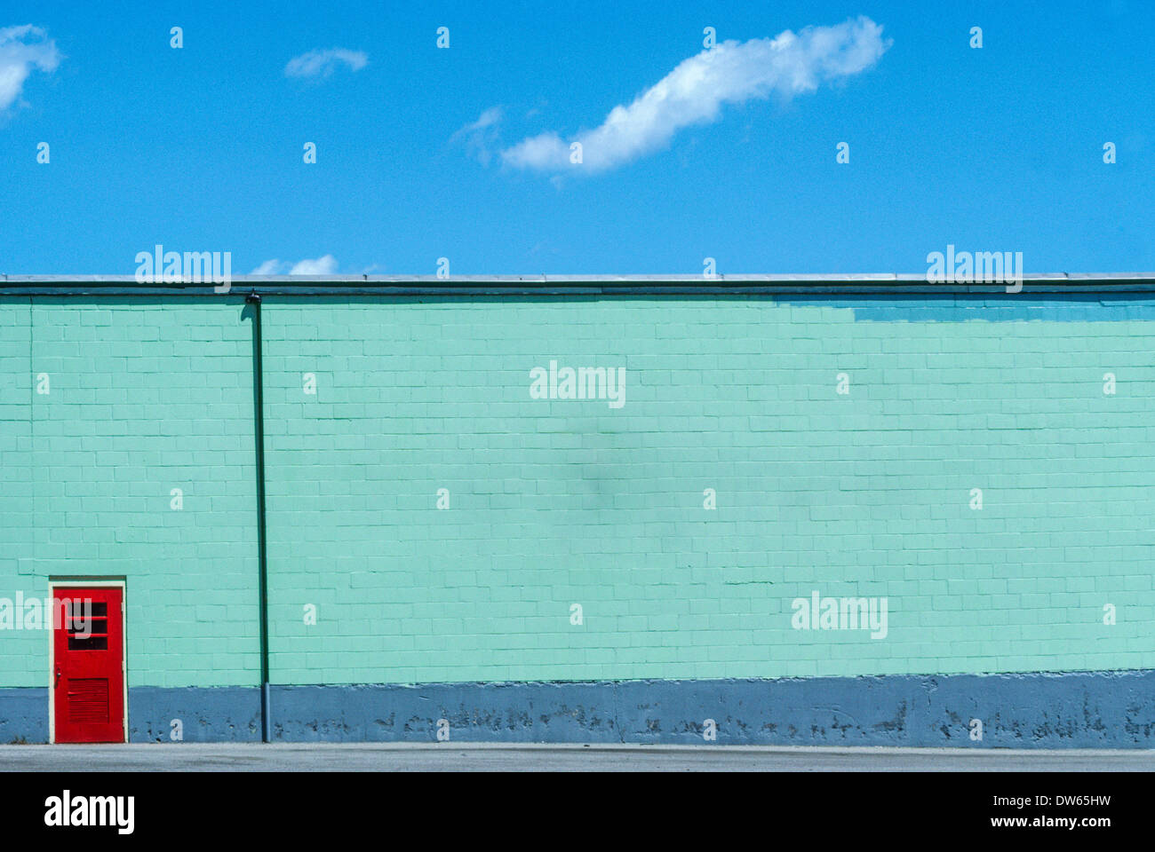 Leuchtend rote Tür in grün und grau Mauerwerk des Fabrikgebäudes ...