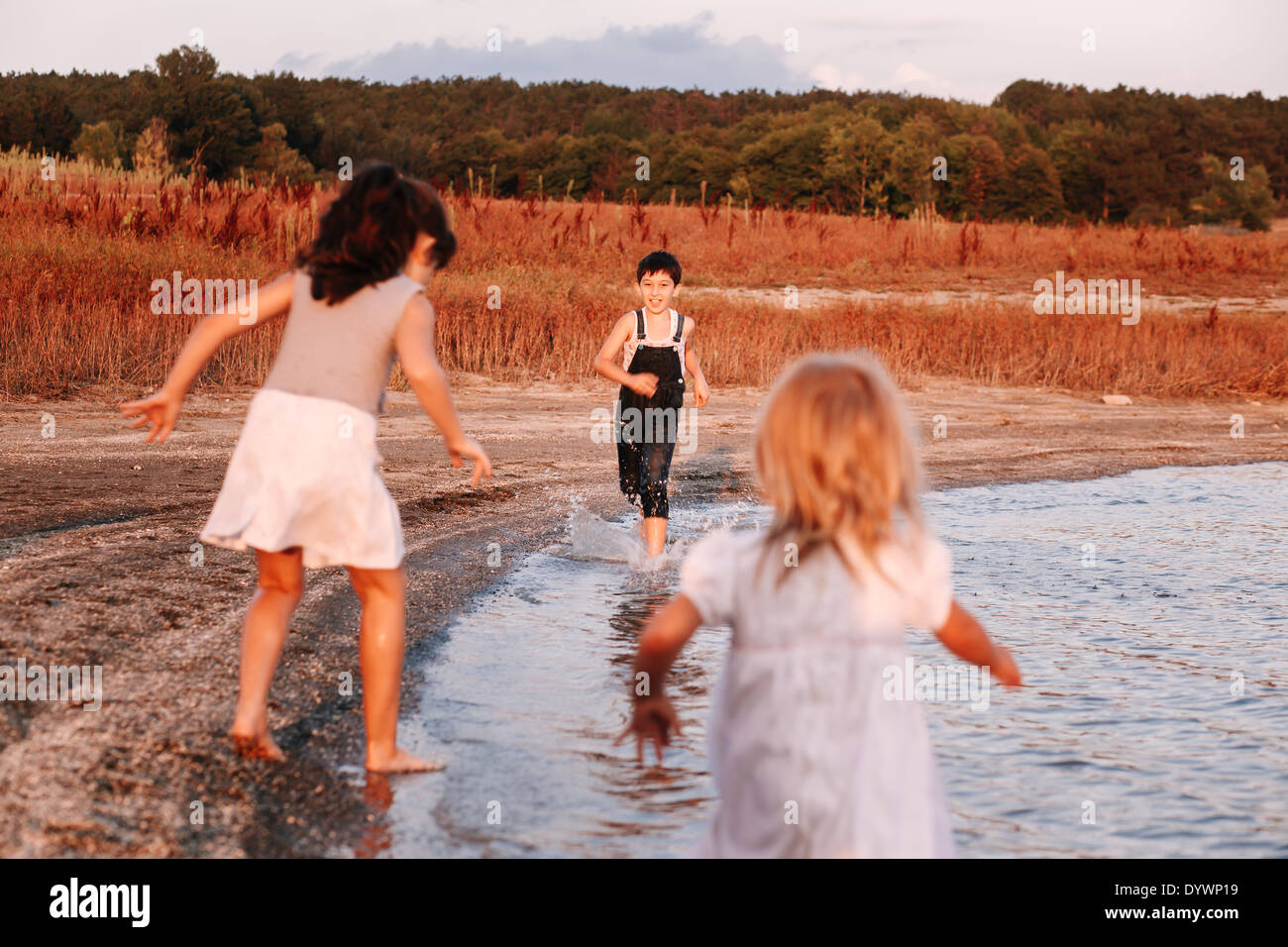Drei kinder, die ins meer laufen -Fotos und -Bildmaterial in hoher ...