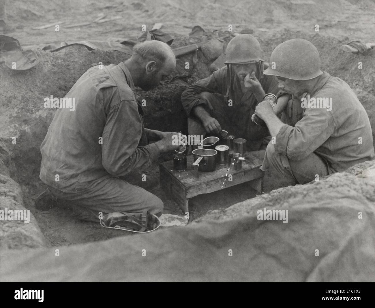 Drei Soldaten der US Army Essen Rationen in einem Erdloch während der ...