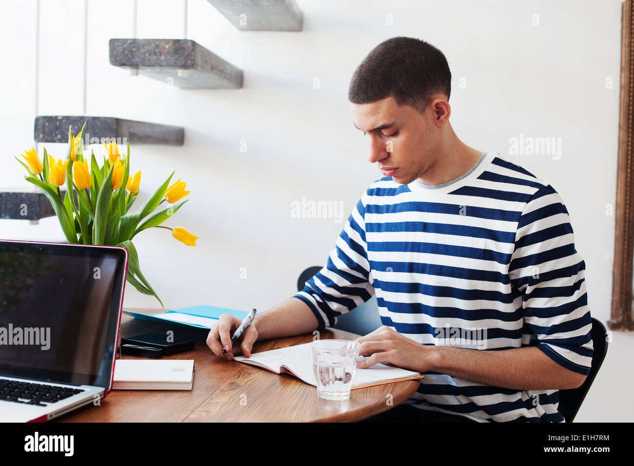Mann am tisch sitzen -Fotos und -Bildmaterial in hoher Auflösung – Alamy