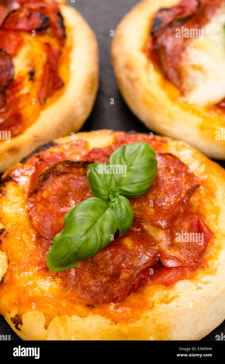 Nahaufnahme von Pizza mit Salami Wurst und Basilikum in Hochformat ...