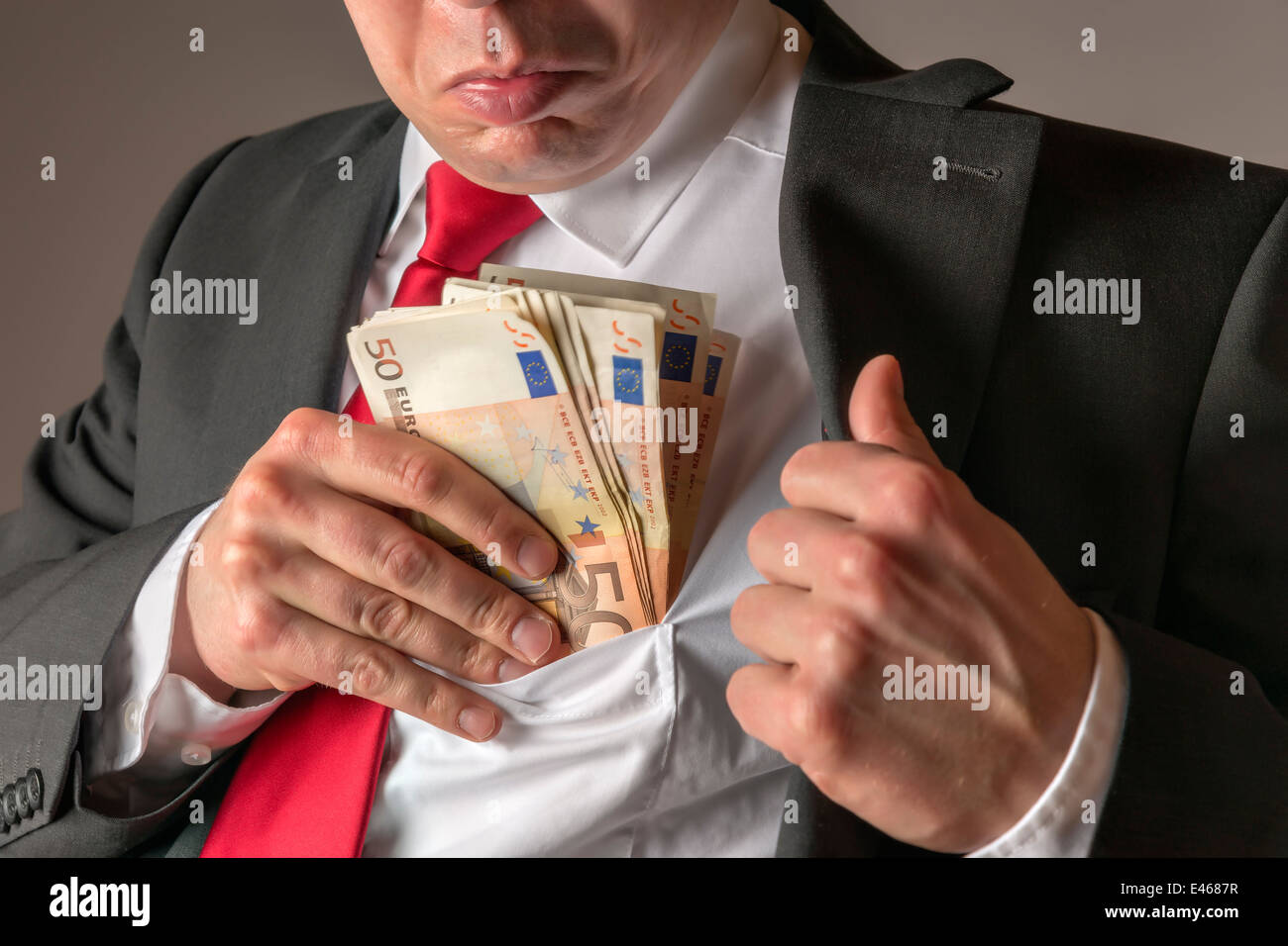 Unternehmer im dunklen Anzug mit Krawatte, Geld in der Tasche ...