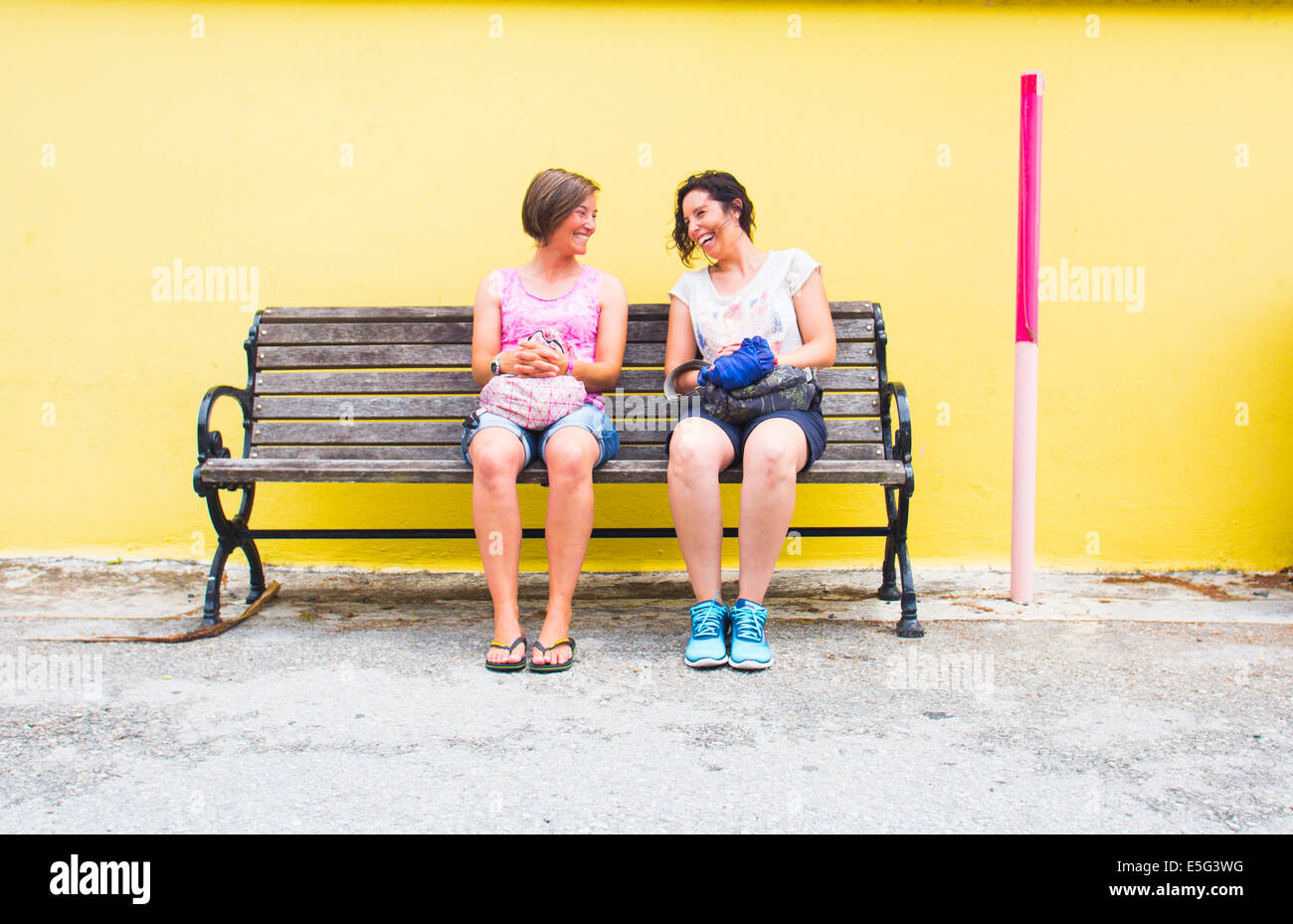 Zwei Frauen sitzen auf Bank und sprechen Stockfotografie - Alamy