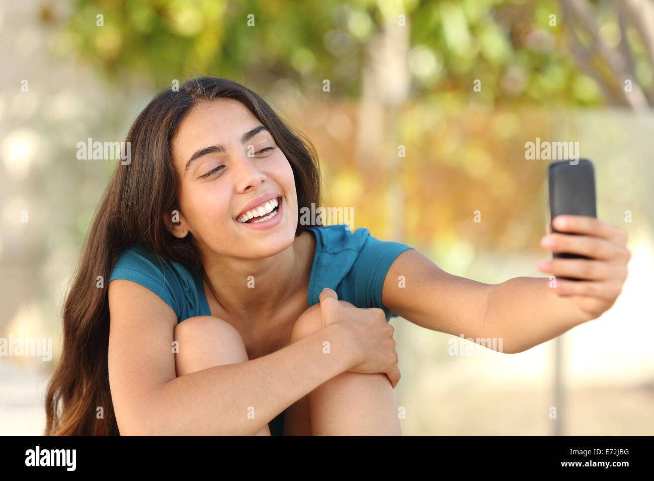 Glücklich lachende Teen Mädchen, die ein Selfie Porträt mit ihrem ... Glücklich lachende Teen Mädchen, die ein Selfie Porträt mit ihrem ...