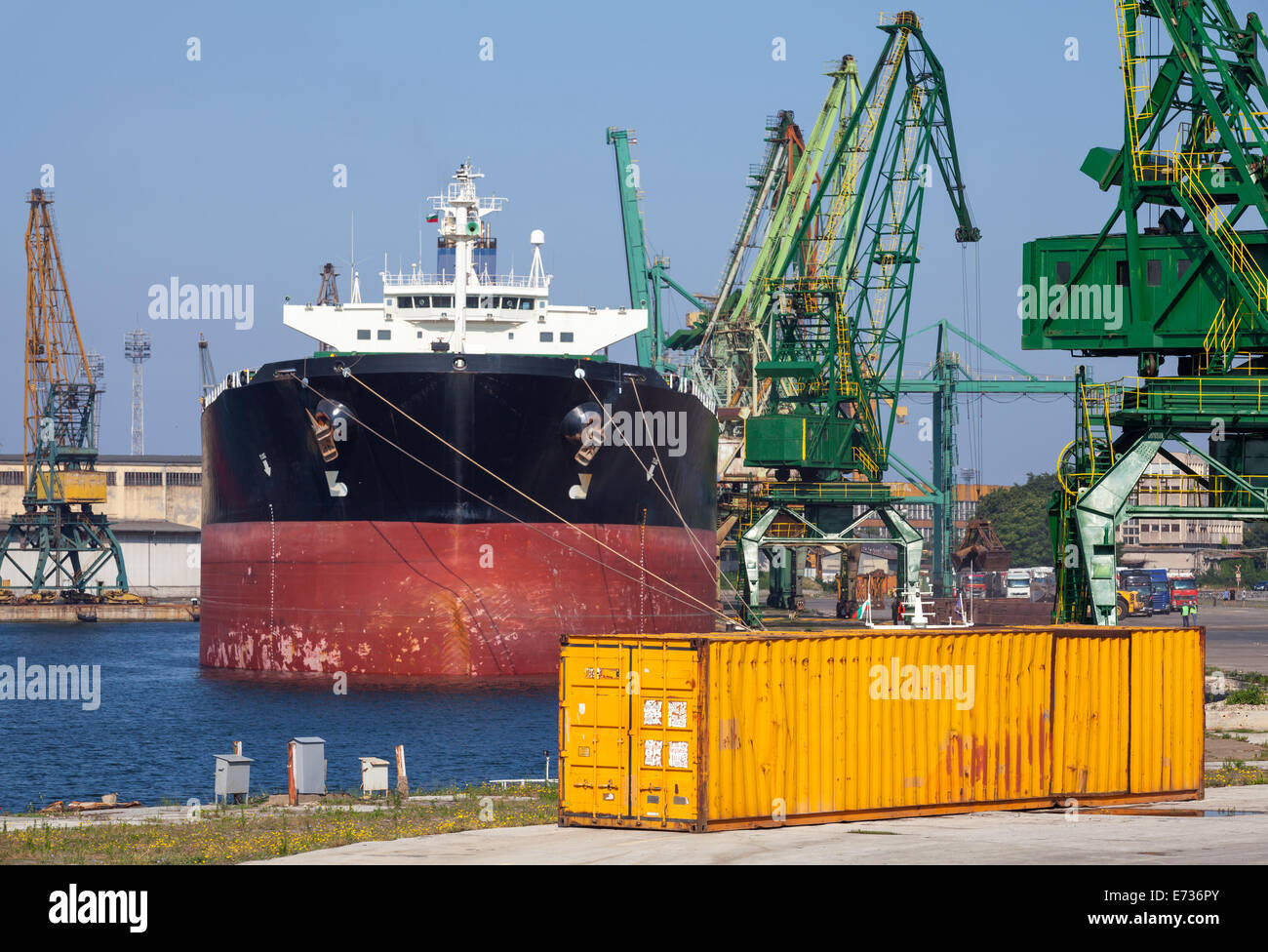 Große industrielle Frachtschiff und gelbe Container stehen im Hafen von ...