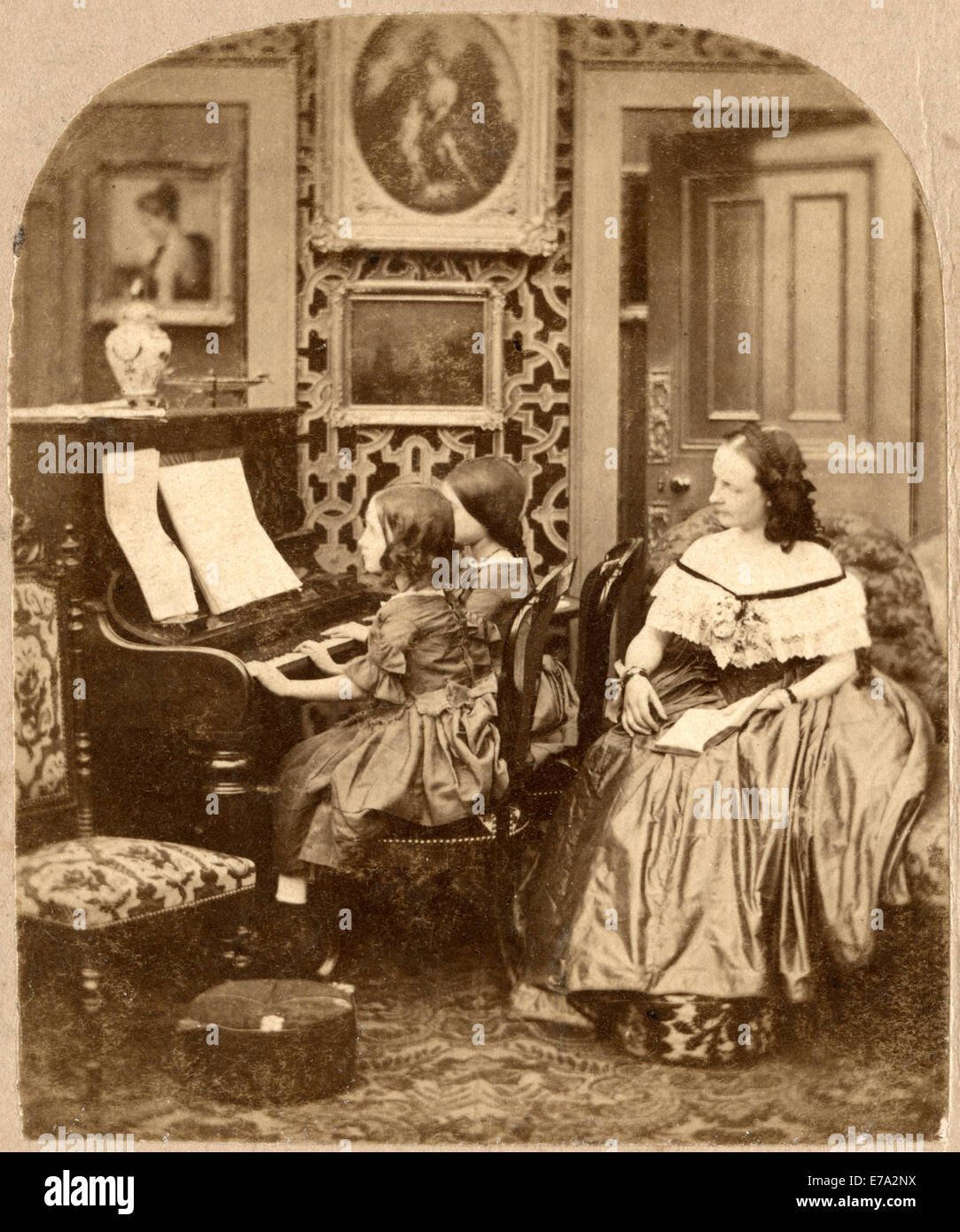 Sitzende Frau hinter zwei sitzende Mädchen spielen Klavier, Abendmusik ...