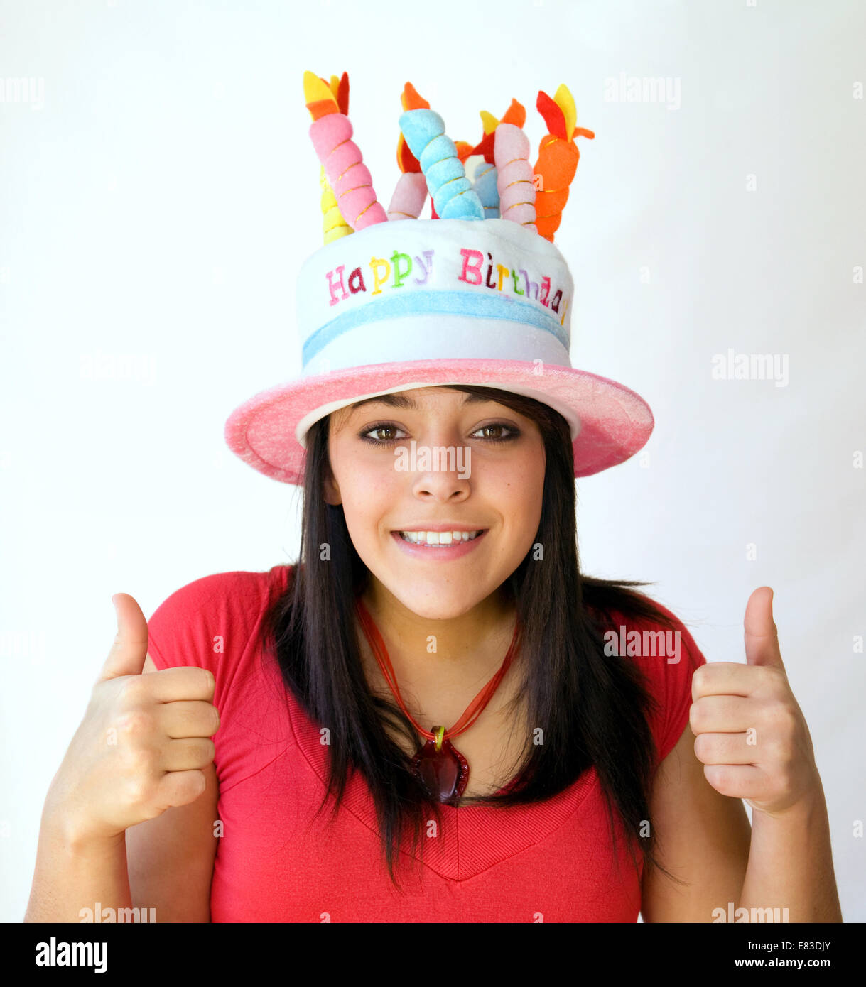 Glückliches junges Mädchen posiert in Happy Birthday Hut und geben ...