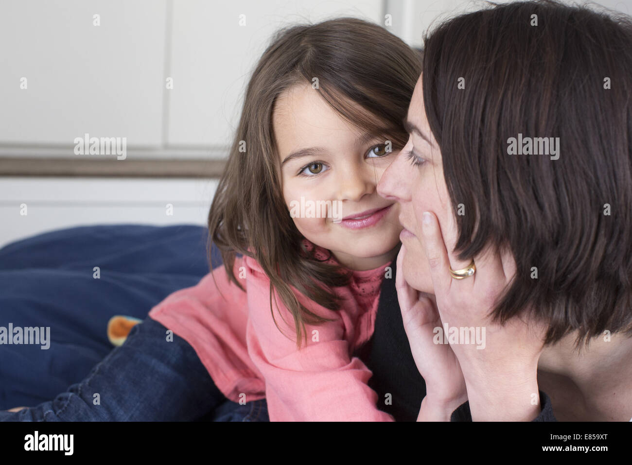 Kleines Mädchen umarmt ihre Mutter und lächelte Stockfotografie - Alamy