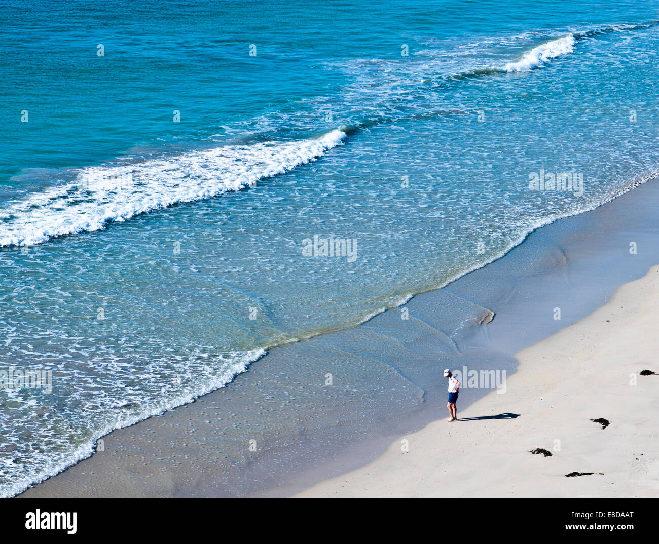 Barfuß Mann steht am Rand des Wassers blickte auf Sand am Strand, die ...