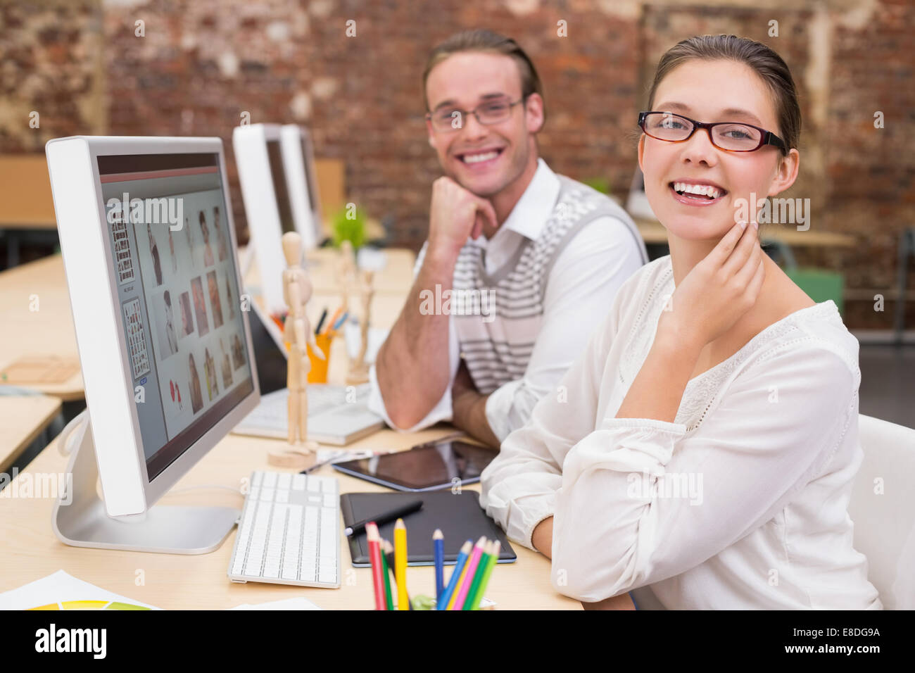Lächelnd Foto-Editoren, die mit dem Computer im Büro Stockfotografie ...