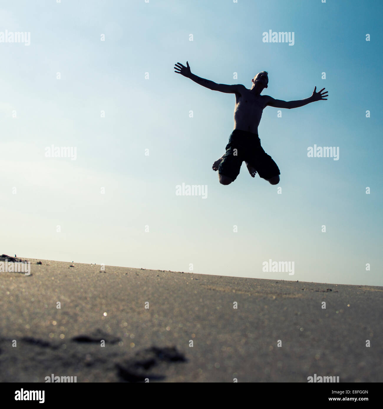 Mann am Strand in die Luft springen Stockfotografie - Alamy
