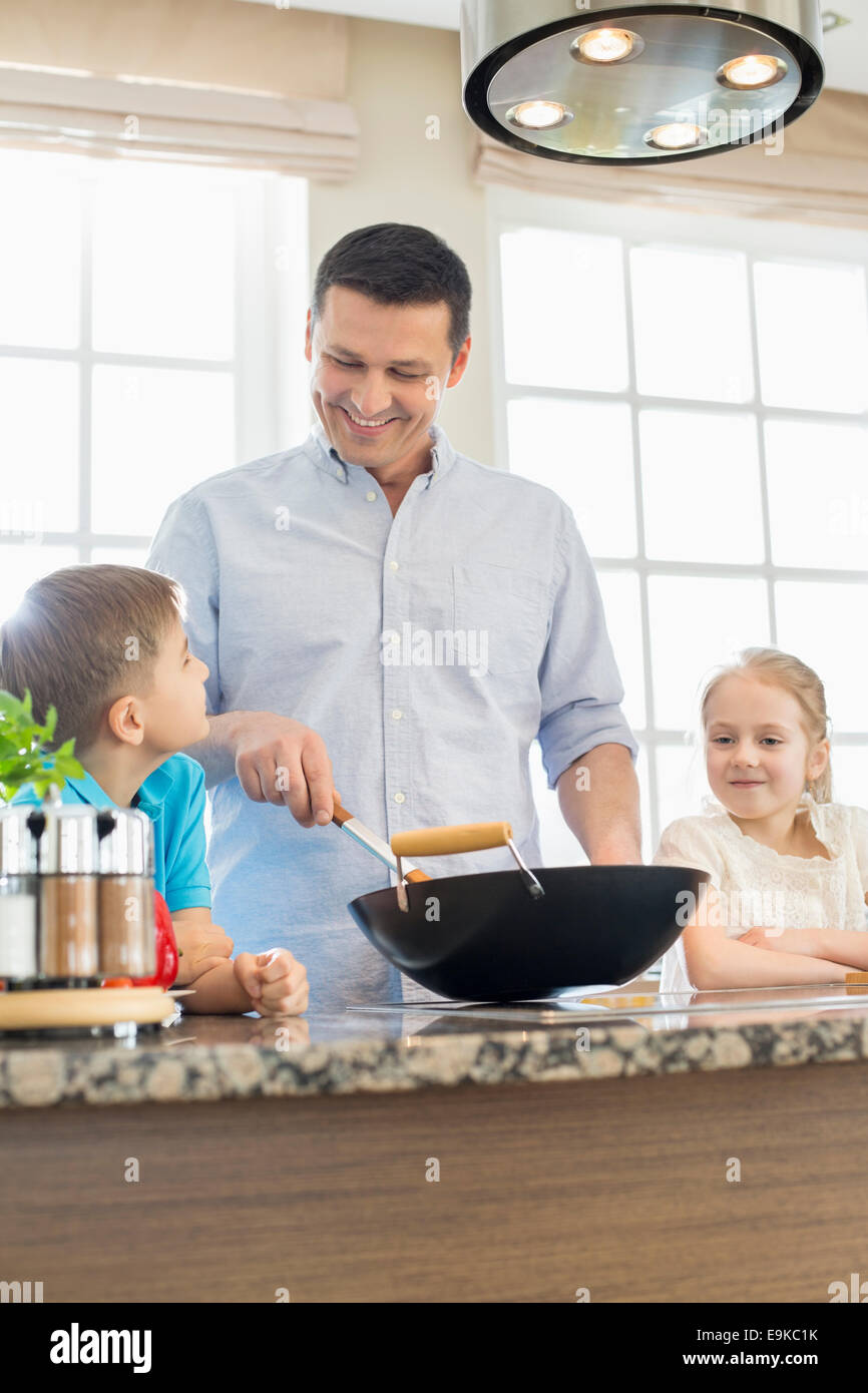Glücklicher Mann mit Kindern, die Zubereitung von Speisen in der Küche ...