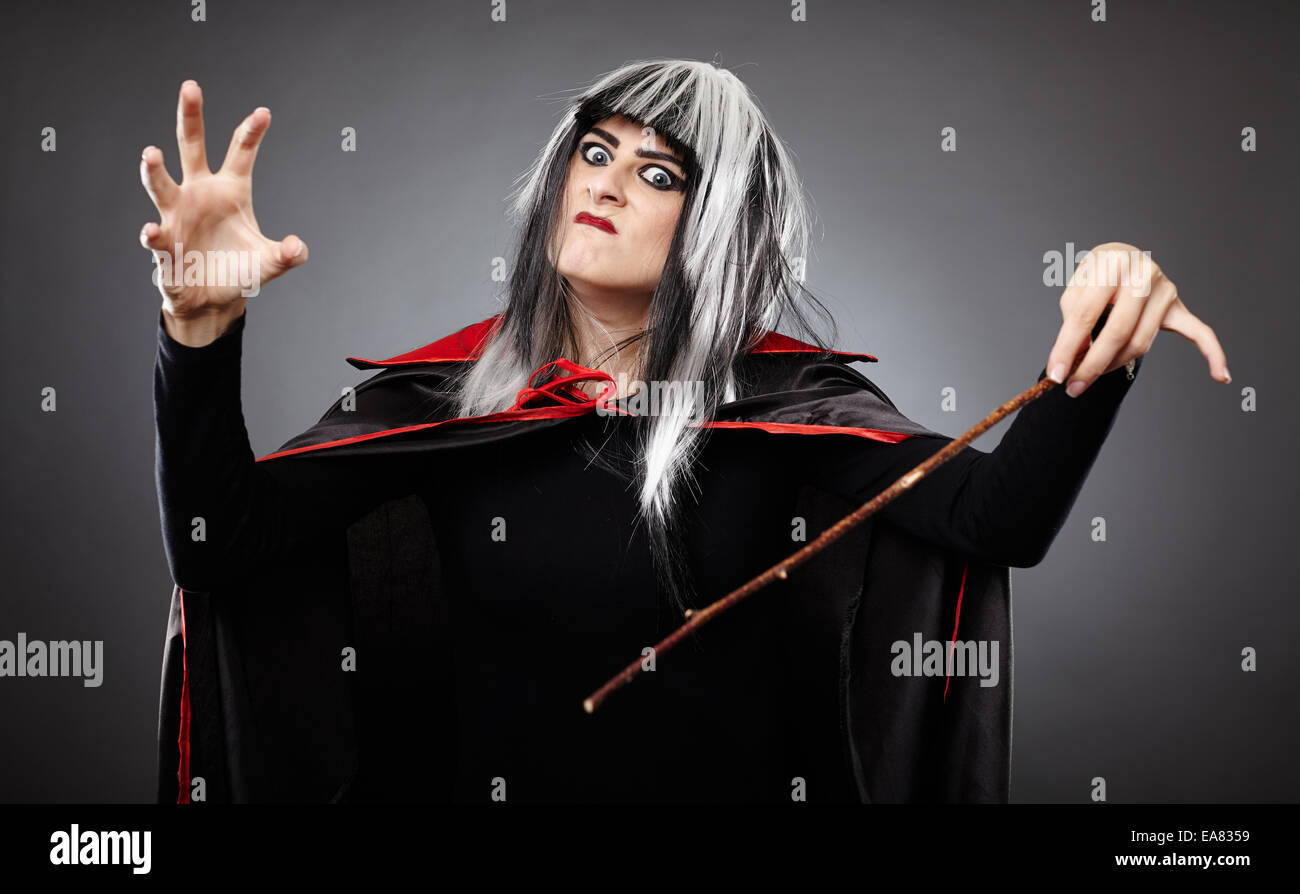 Junge gruselige Hexe macht einen Zauber mit ihren Zauberstab, Halloween ...