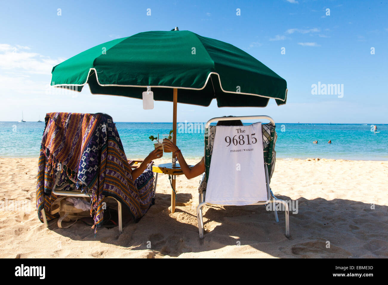 Zwei Frauen, die einen Drink am Strand unter Dach Stockfotografie - Alamy