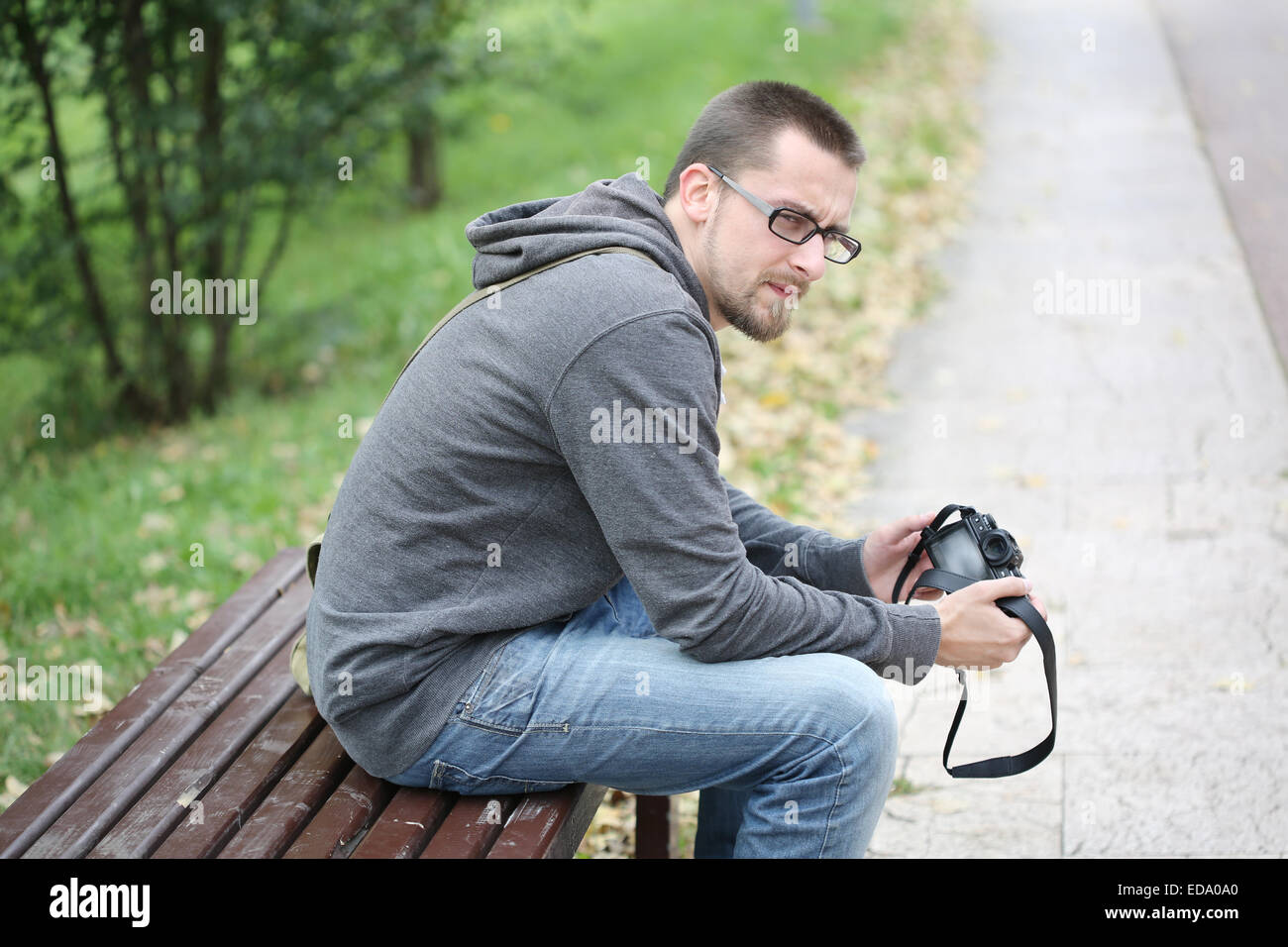 Mann sitzt auf bank unter baum in einem park -Fotos und -Bildmaterial ...