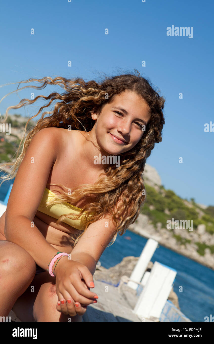 Schöne Teenager-Mädchen mit langen lockigen blonden Haaren am Meer ... Schöne Teenager-Mädchen mit langen lockigen blonden Haaren am Meer ...