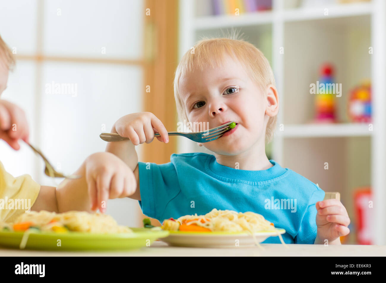 Kid Boy Spaghetti-Essen im Kindergarten Stockfotografie - Alamy