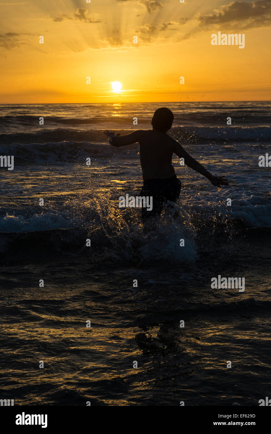 Junge, Baden am Strand in der Abenddämmerung am Strand in Andalusien ...