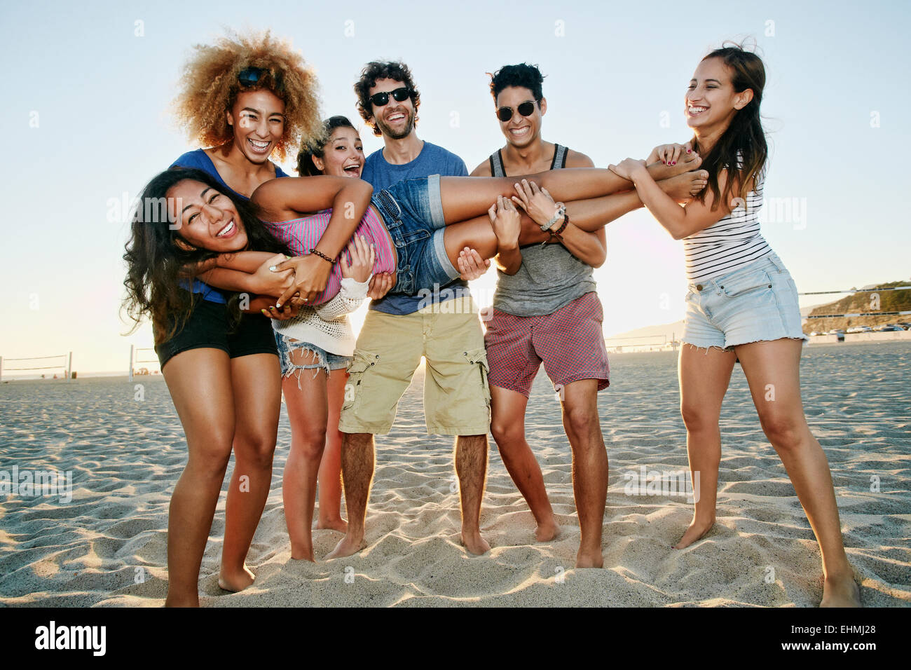 Freunde, die zusammen am Strand posiert lächelnd Stockfotografie - Alamy