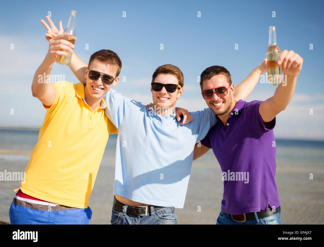 Glückliche Freunde mit Bierflaschen am Strand Stockfotografie - Alamy