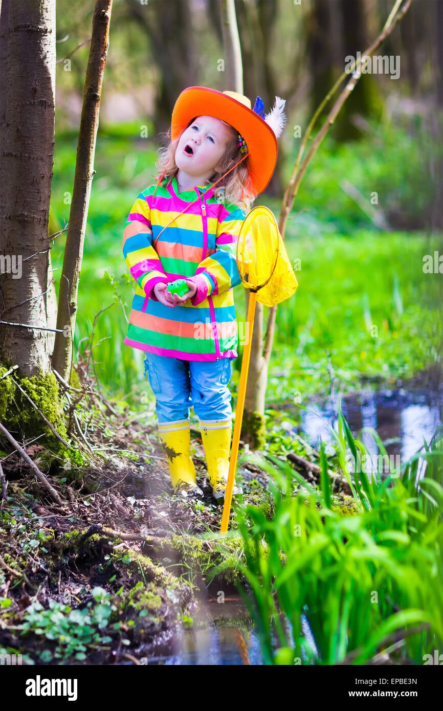 Kinder spielen im Freien. Vorschulkind Kind fangen Frosch mit bunten ...