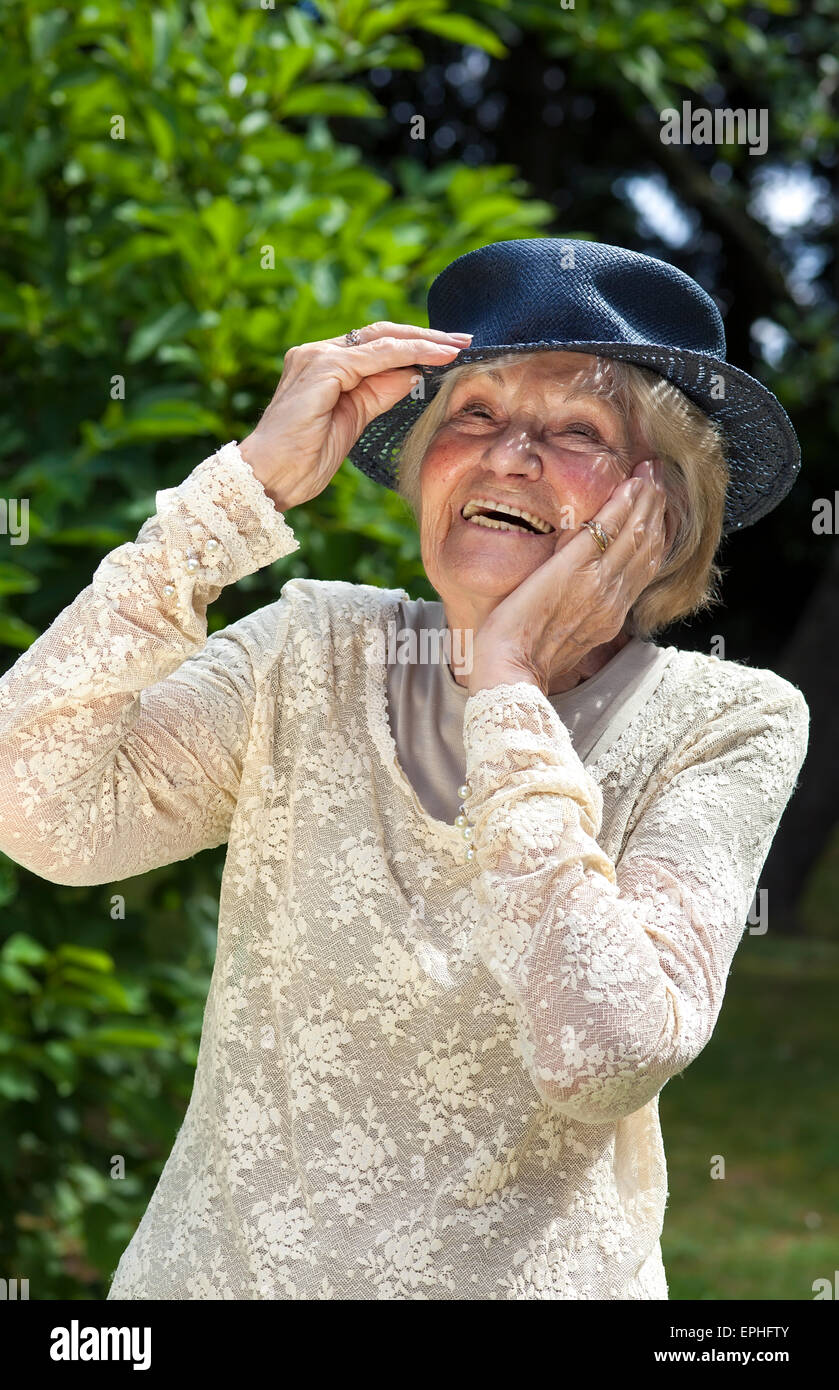 Lebhafte ältere Dame mit einem Hut und eleganter Spitze oben Lachen ...