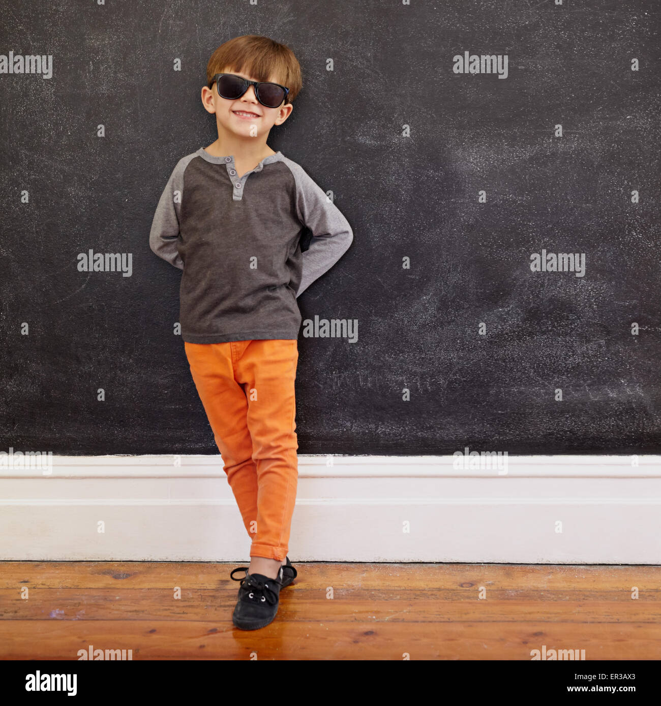 Voller Länge Schuss stilvollen kleinen Jungen vor der Tafel stehen. Kaukasische Kind mit ...