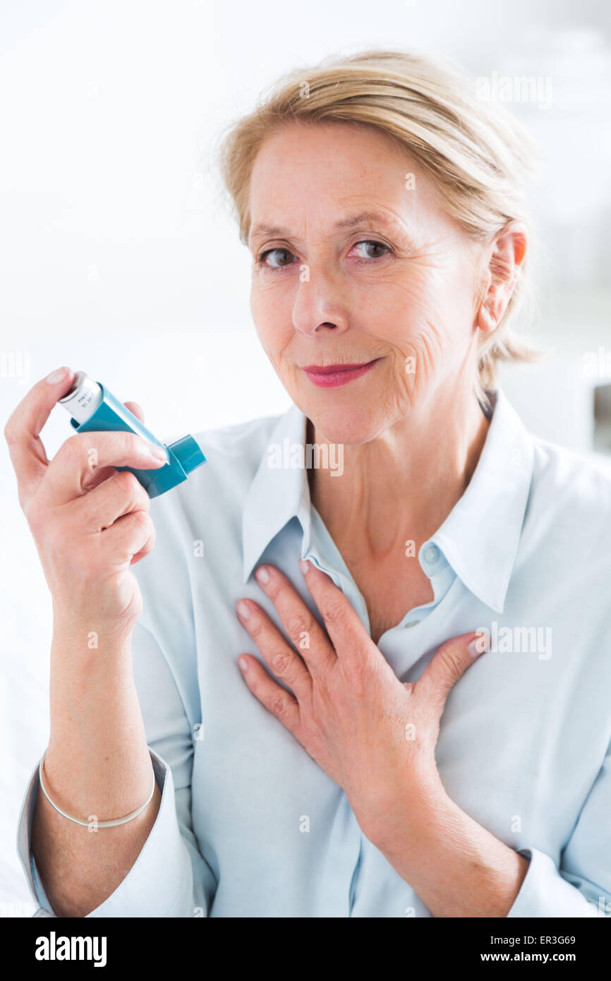 Frau mit einem Aerosol-Inhalator, der Bronchodilatator zur Behandlung ...