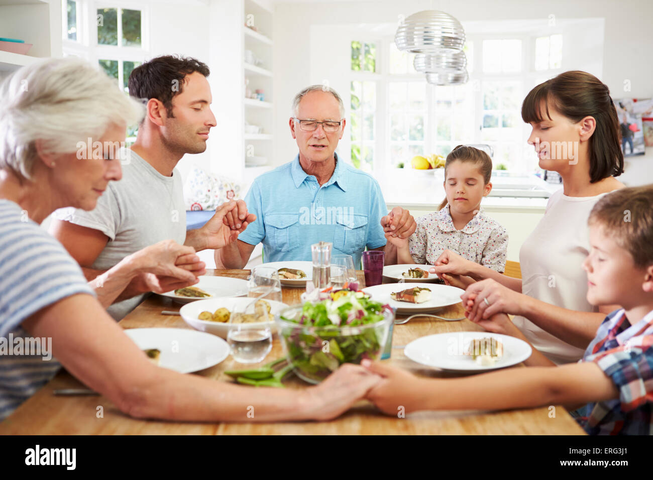Multi-Generationen-Familie beten vor dem Essen zu Hause Stockfotografie ...