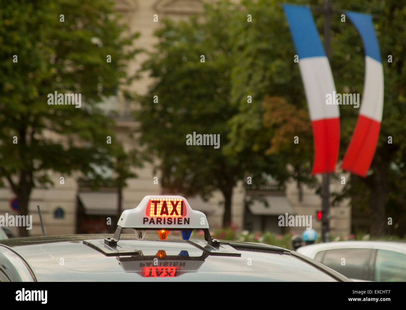 Taxischild und seine Reflexion auf dem Dach von einem Taxi mit Flaggen ...