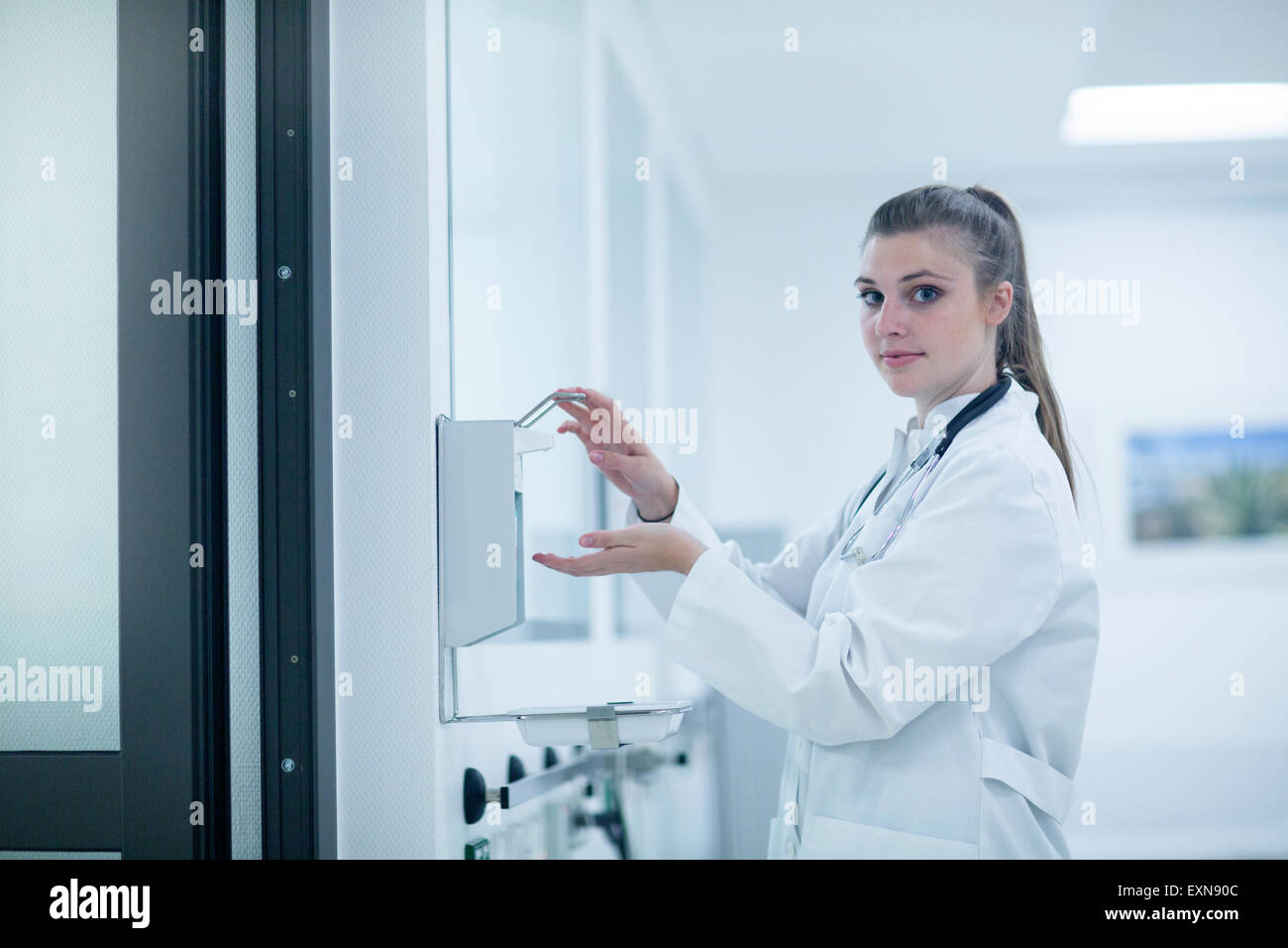 Junge Ärztin im Krankenhaus ihre Hände desinfizieren Stockfotografie ... Junge Ärztin im Krankenhaus ihre Hände desinfizieren Stockfotografie ...