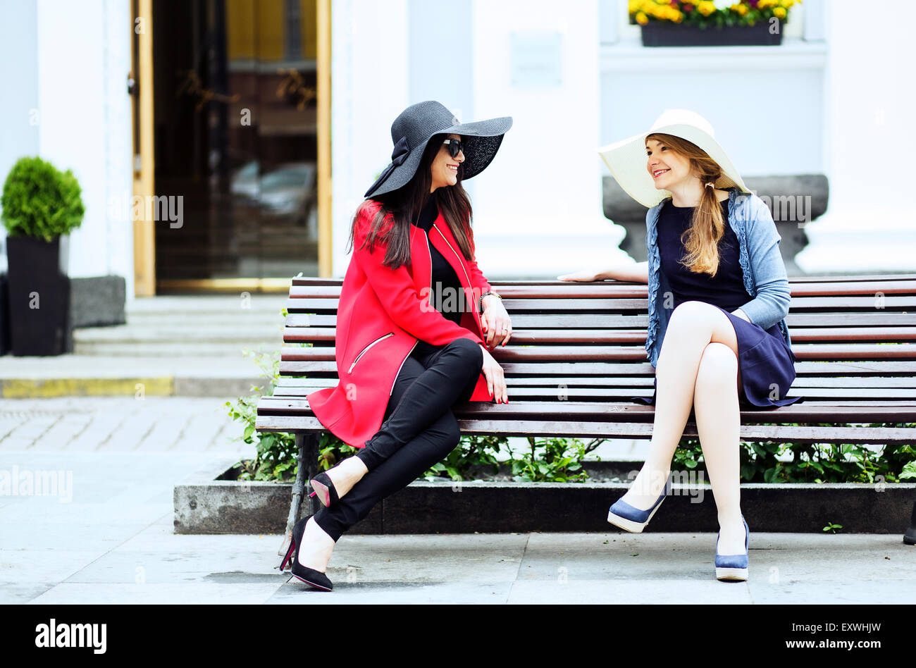 Zwei Frauen sitzen auf einer Bank zusammen Stockfotografie - Alamy