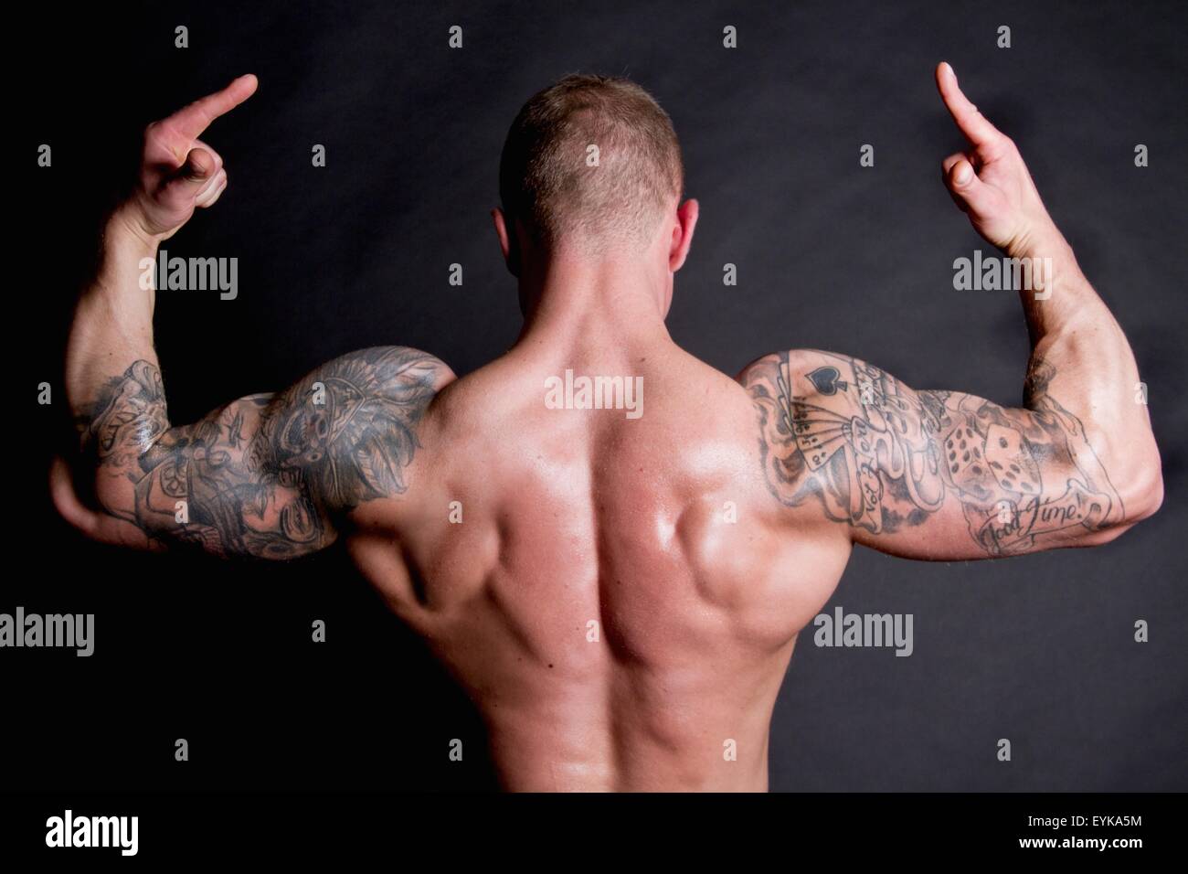 Junger Mann zeigt hinten Doppel Bizeps Stockfotografie - Alamy