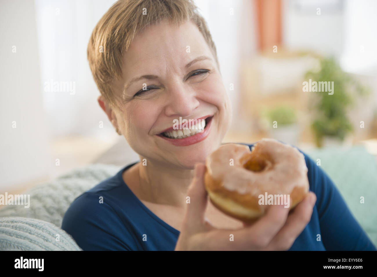 Frau, die donut isst -Fotos und -Bildmaterial in hoher Auflösung – Alamy