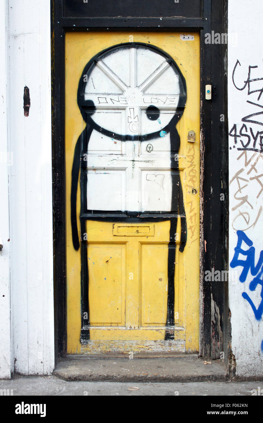 Graffiti-Cartoon-Figur gemalt auf gelbe Tür, Brick Lane, London ...