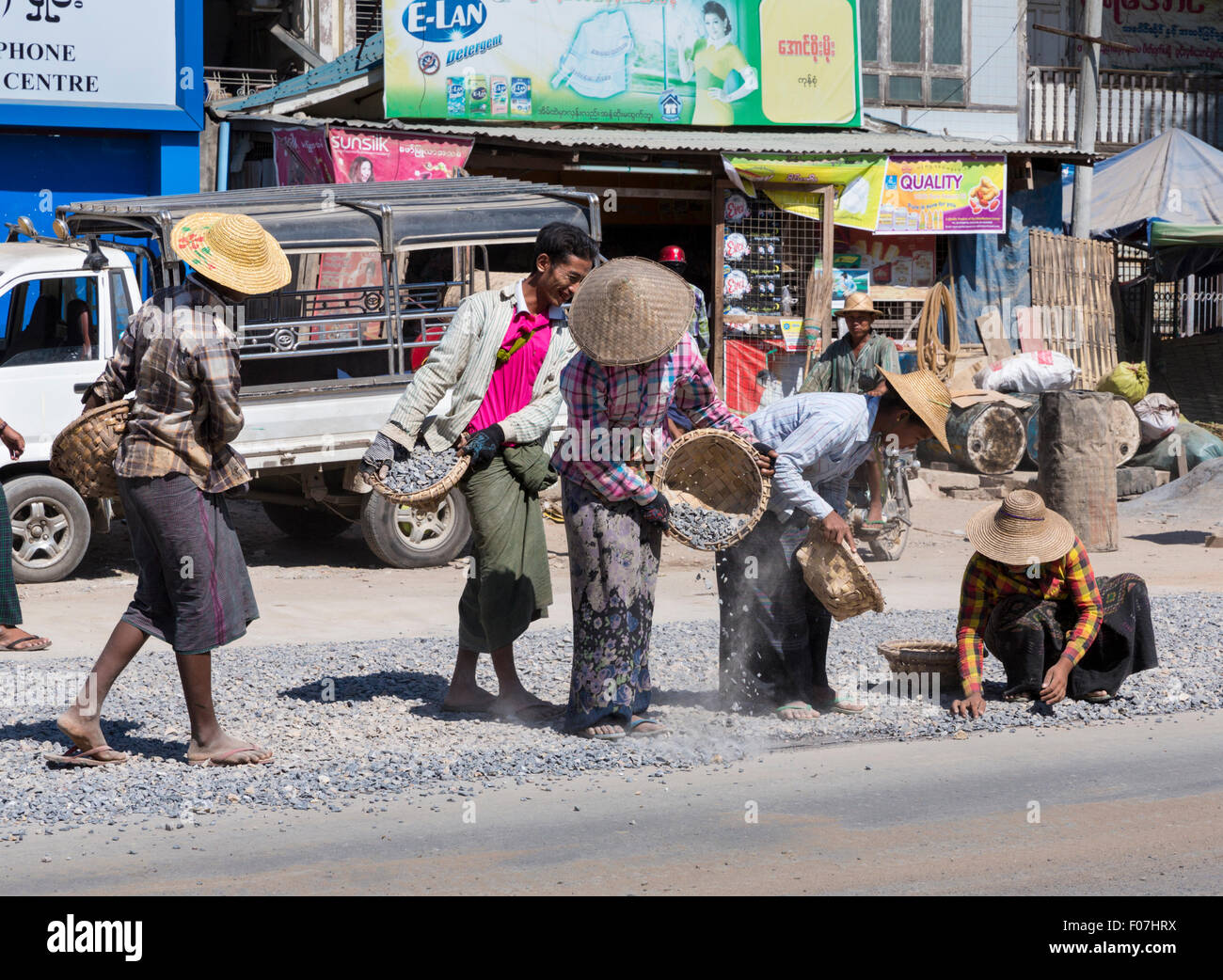 Arbeiter tragen Kies mit der hand, wie sie bereiten eine Straße in Ohn ...