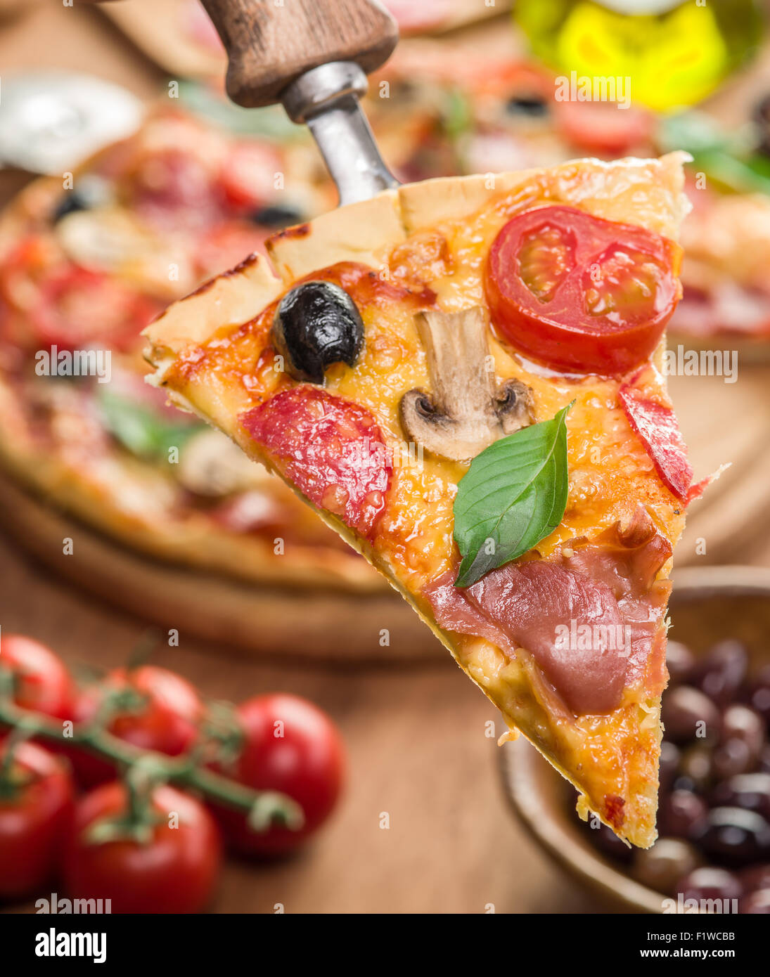 Stück Pizza mit Champignons, Schinken und Tomaten. Ansicht von oben ...