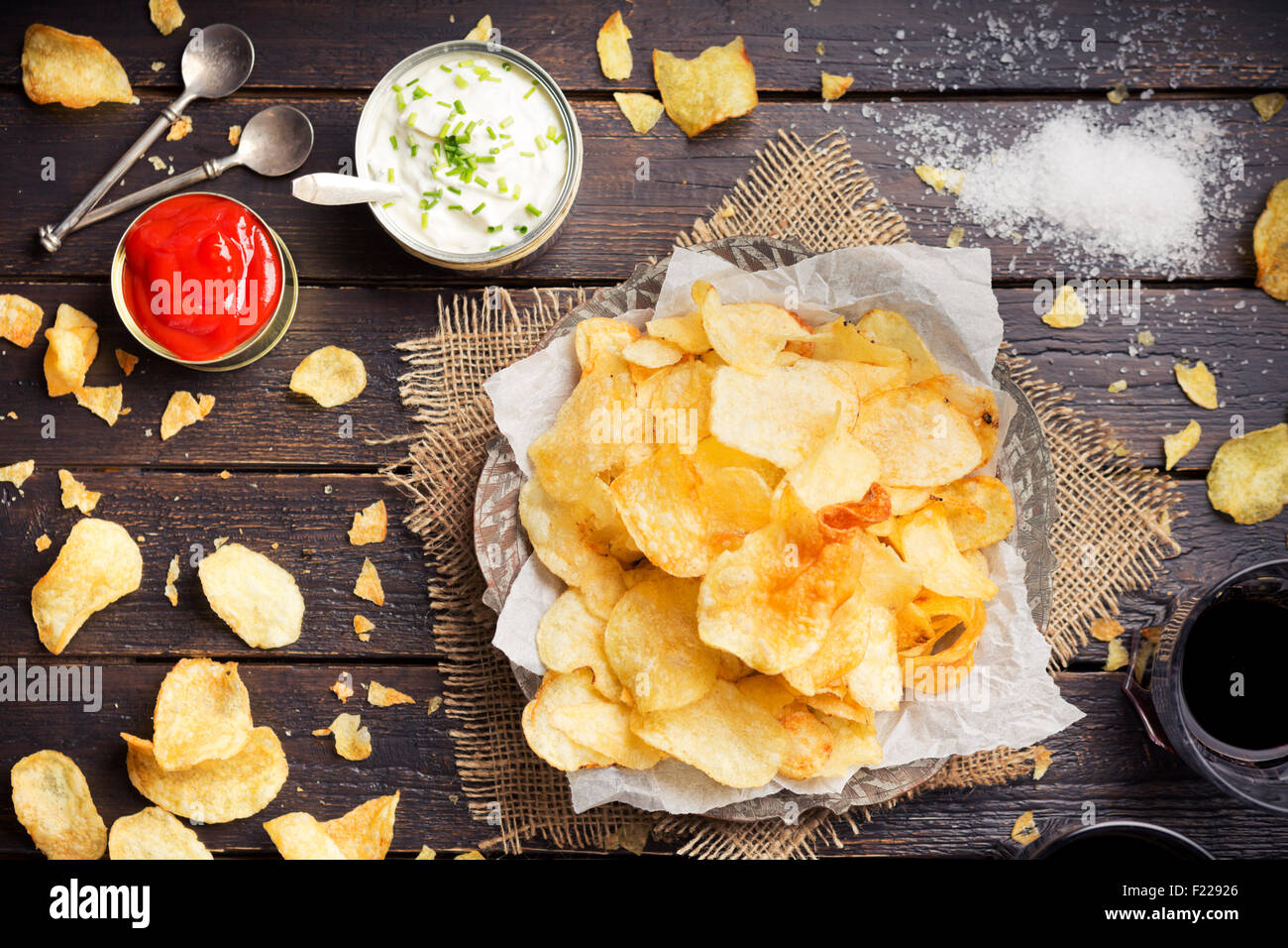 Kartoffel-Chips mit Dip-Saucen auf einem rustikalen Tisch. Direkt von ...
