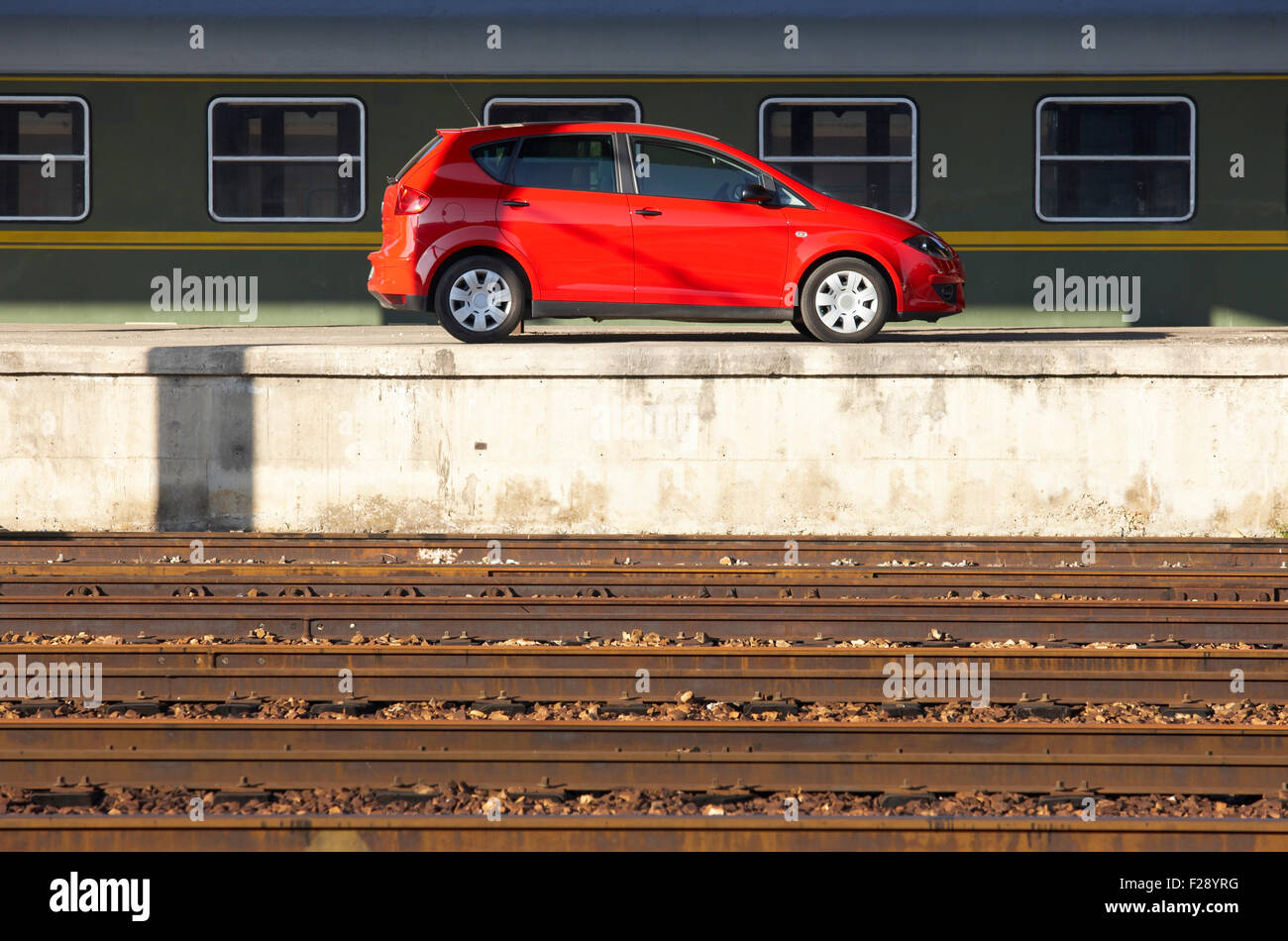 Rotes Auto auf Bahn Bahnsteig mit Schienen und Wagen auf Hintergrund ...