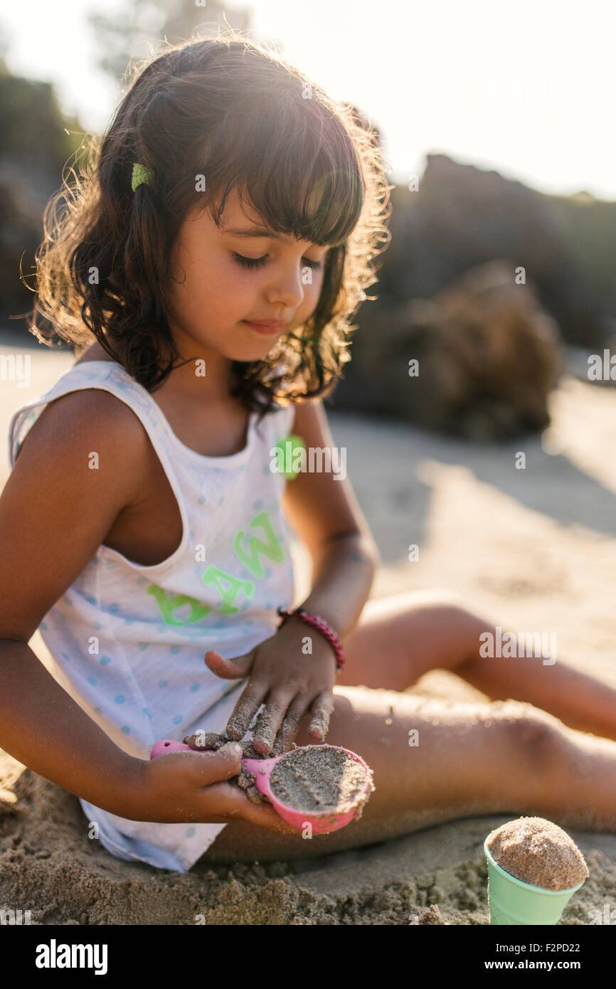 Spanien, Llanes, kleine Mädchen spielen mit Sand am Strand ...