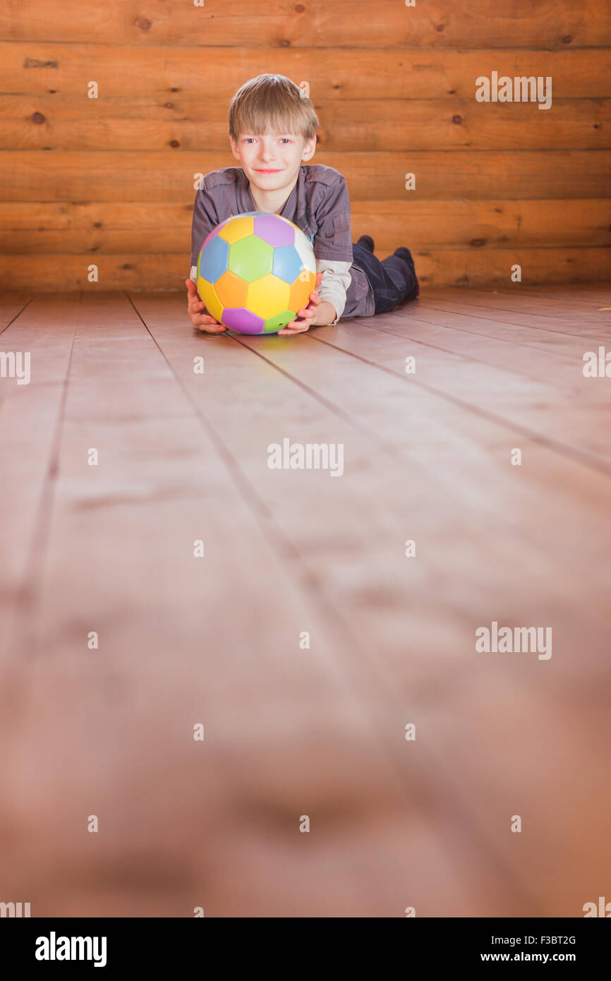 Junge mit einem Ball im Interieur aus Holz Stockfotografie - Alamy
