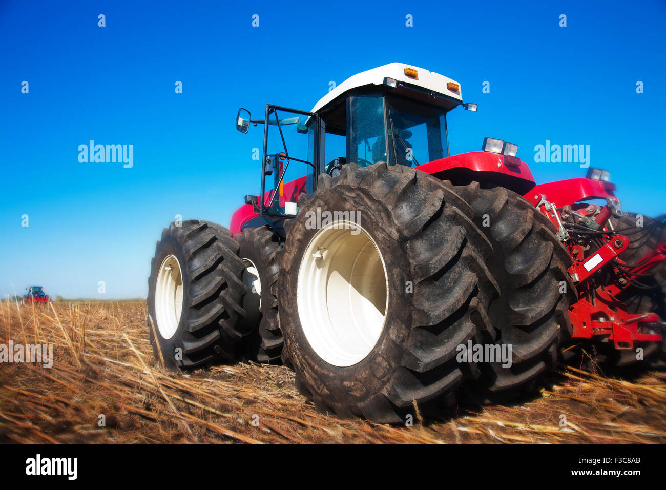 Roter Traktor im Feld an einem sonnigen Tag Stockfotografie - Alamy