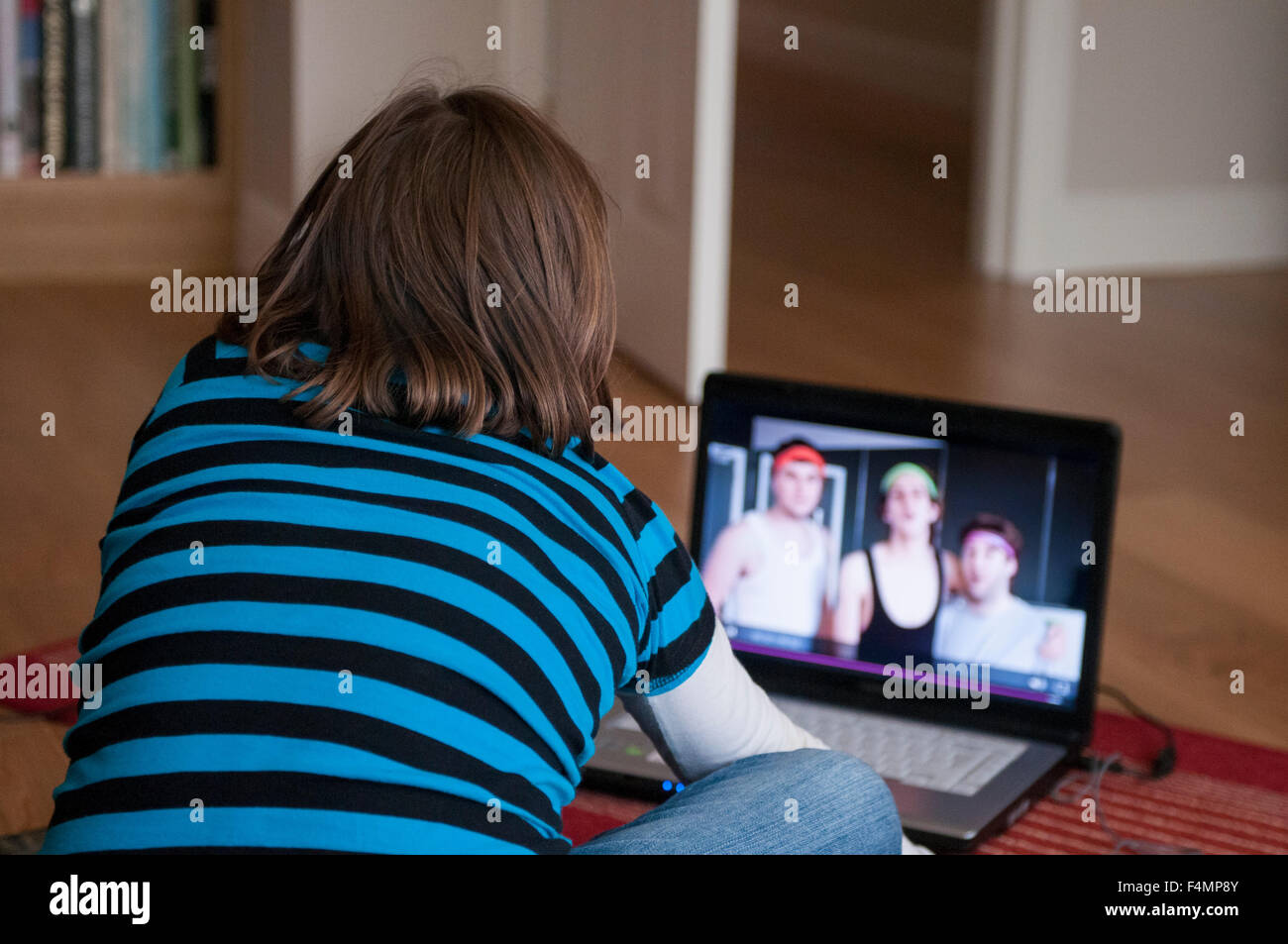 Rückansicht eines 9 Jahre alten Kindes (Mädchen) sitzen auf dem Boden ...