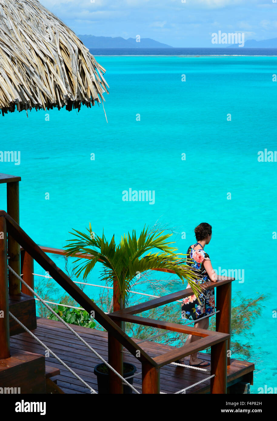 Weibliche Touristen auf dem Balkon einen Overwater Bungalow mit ...