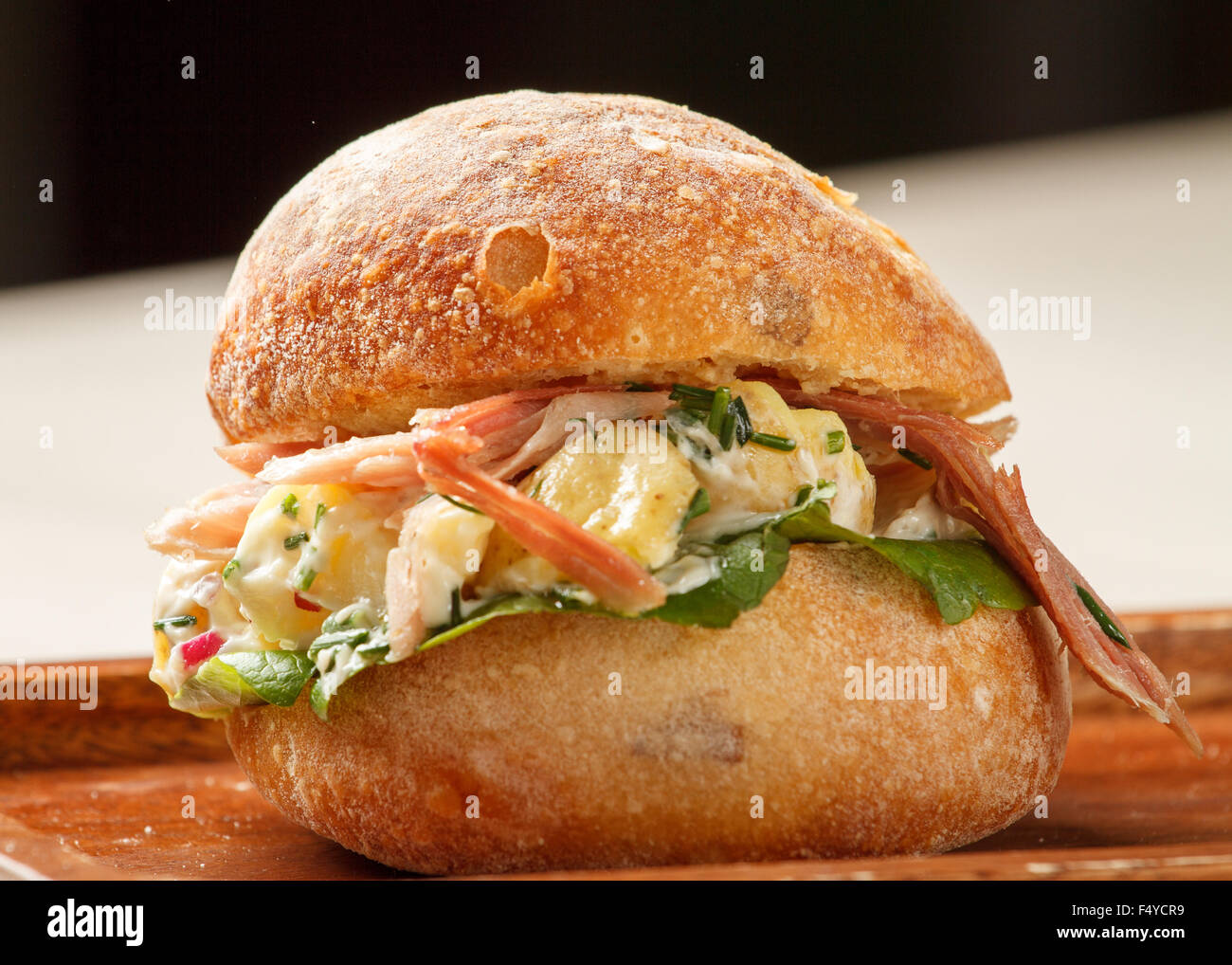 Sandwich in einem Brötchen mit Speck und Kartoffelsalat gemacht ...