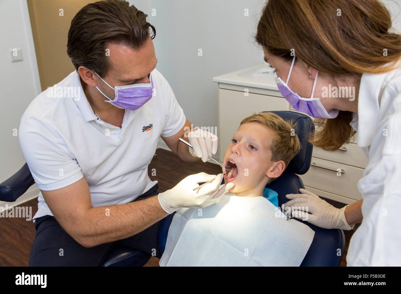 Zahnarztpraxis, Zahnarzt, Assistant und jungen Patienten, zahnärztliche Behandlung, Vorbeugung ...