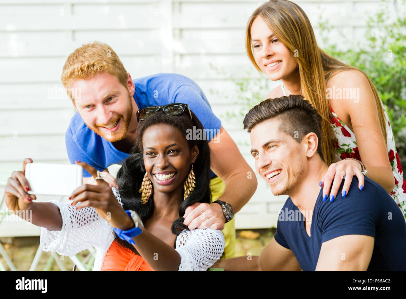 Eine Gruppe von Freunden einen Tisch sitzen und reden, Lächeln, während ...