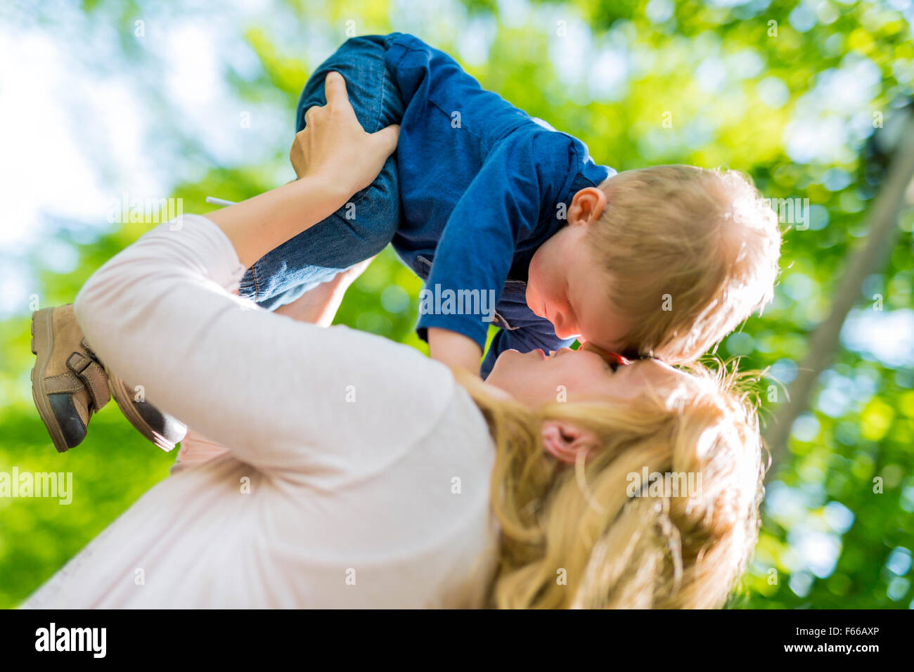 Schöne junge Mutter spielen und lächelnd mit ihrem hübschen kleinen ...