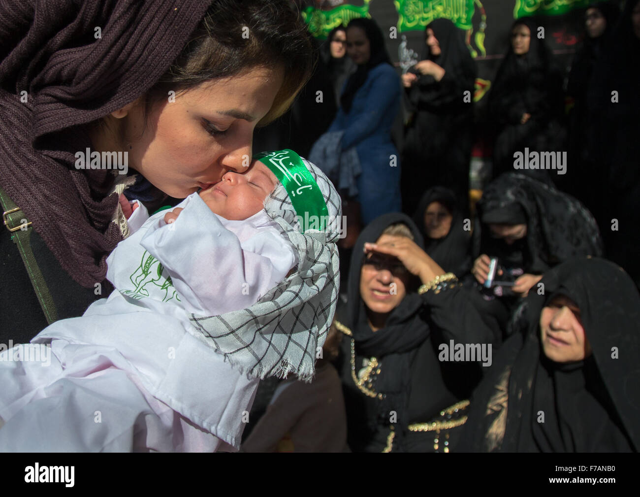 Iranische Schiiten Muslimin küssen ihr Baby während Ashura fest, den ...