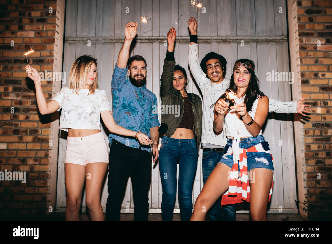 Glückliche junge Menschen, in der Nacht, feiert mit Wunderkerzen. Junge ...